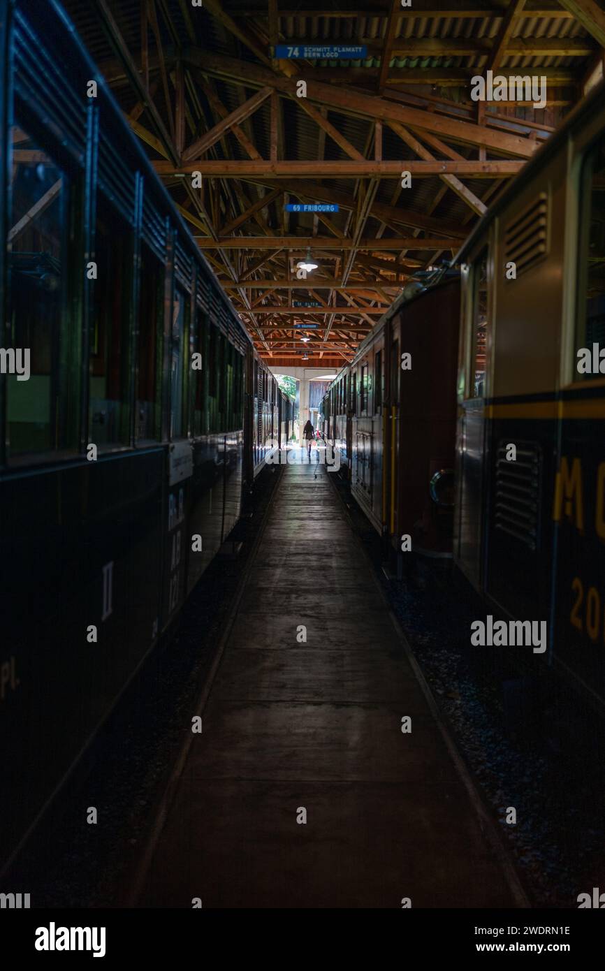 A woman walking on a narrow walkway at the train station Stock Photo ...