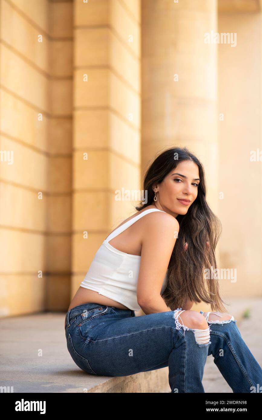 Beautiful woman sat outdoors looking at camera smiling Stock Photo - Alamy