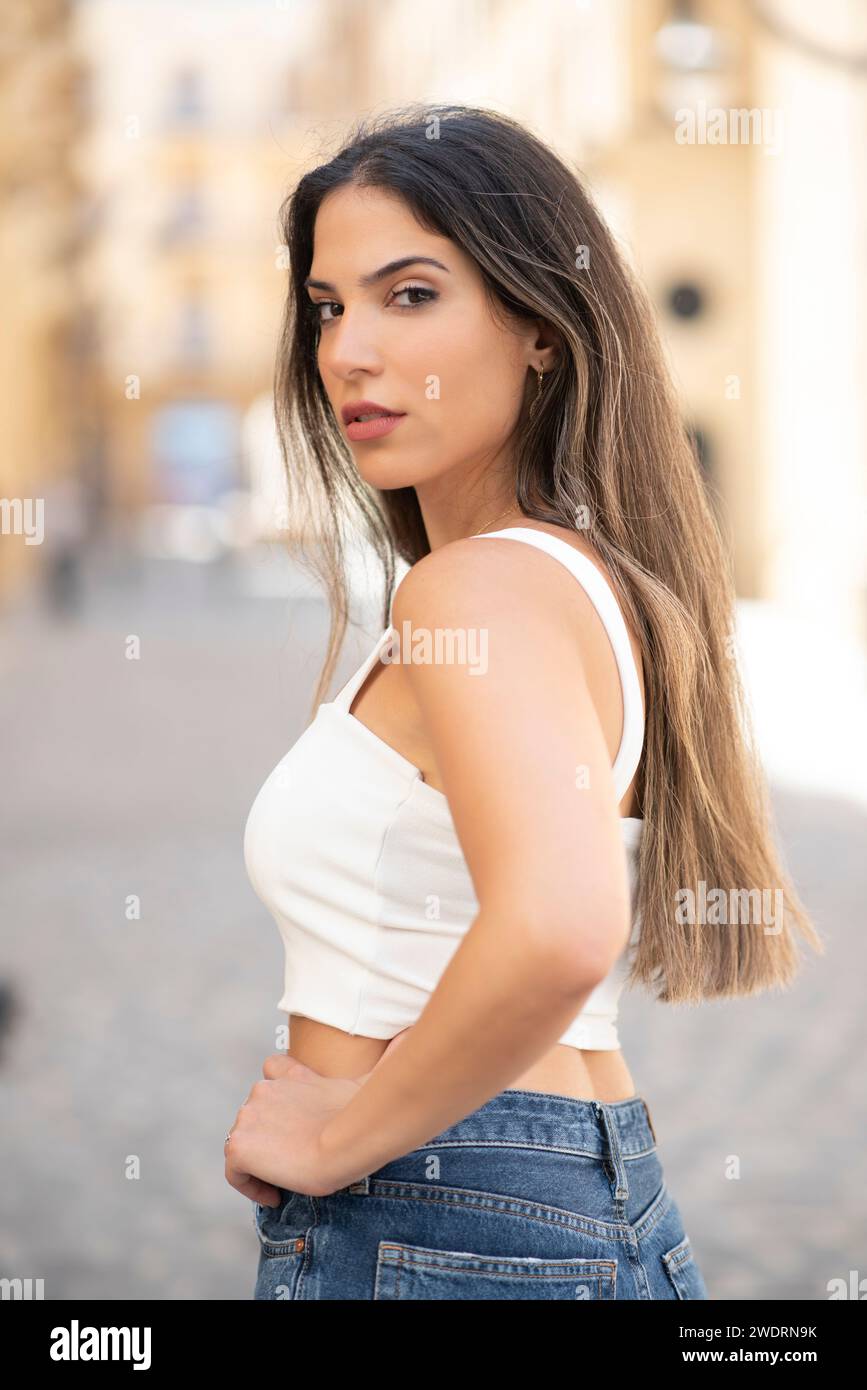 Serious young woman looking over shoulder Stock Photo - Alamy