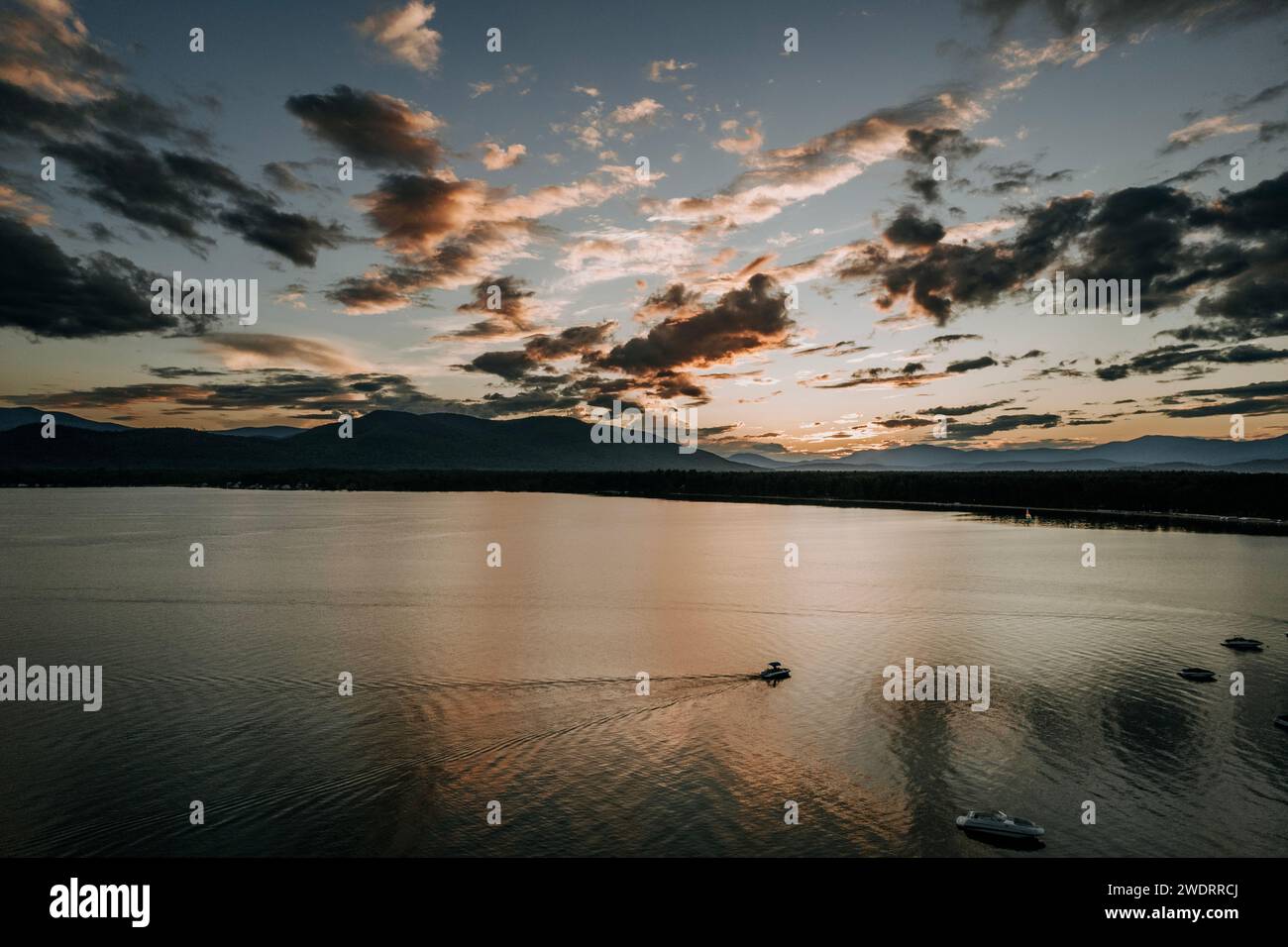 Aerial view of boat traversign Ossipee Lake at sunset New Hampshire ...