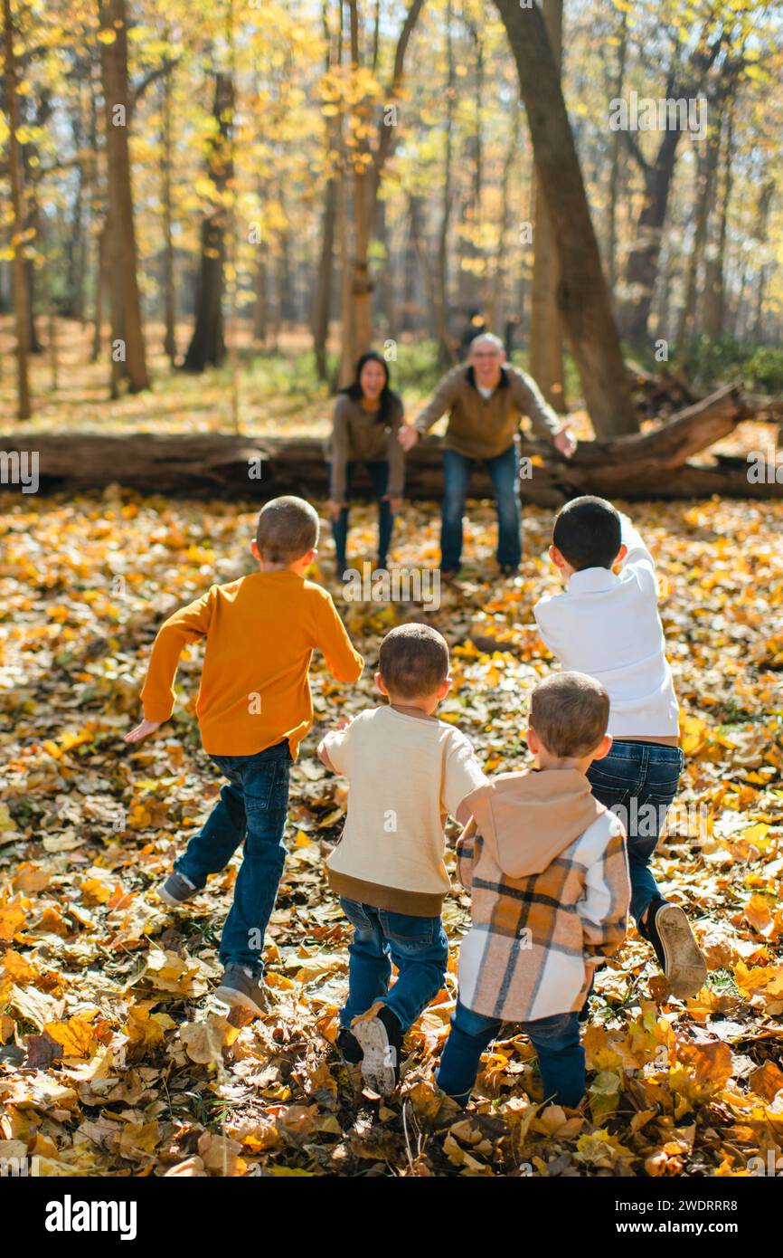 Back view of children running to parents in autumn forest Stock Photo ...