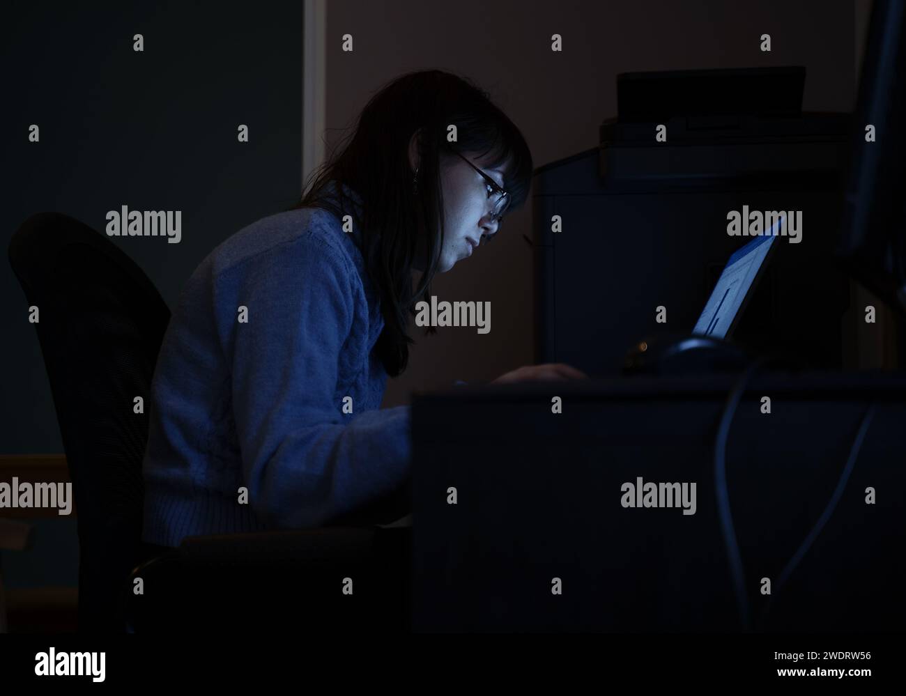Software developer woman working late in the night on her laptop at her ...