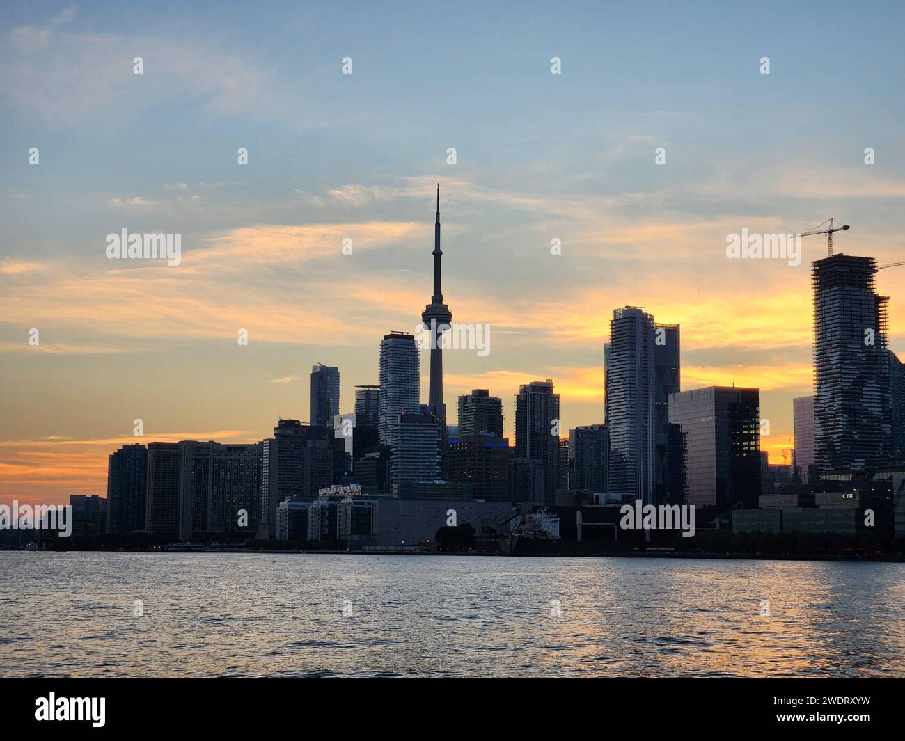 A stunning sunset view of the Toronto skyline across the tranquil lake ...