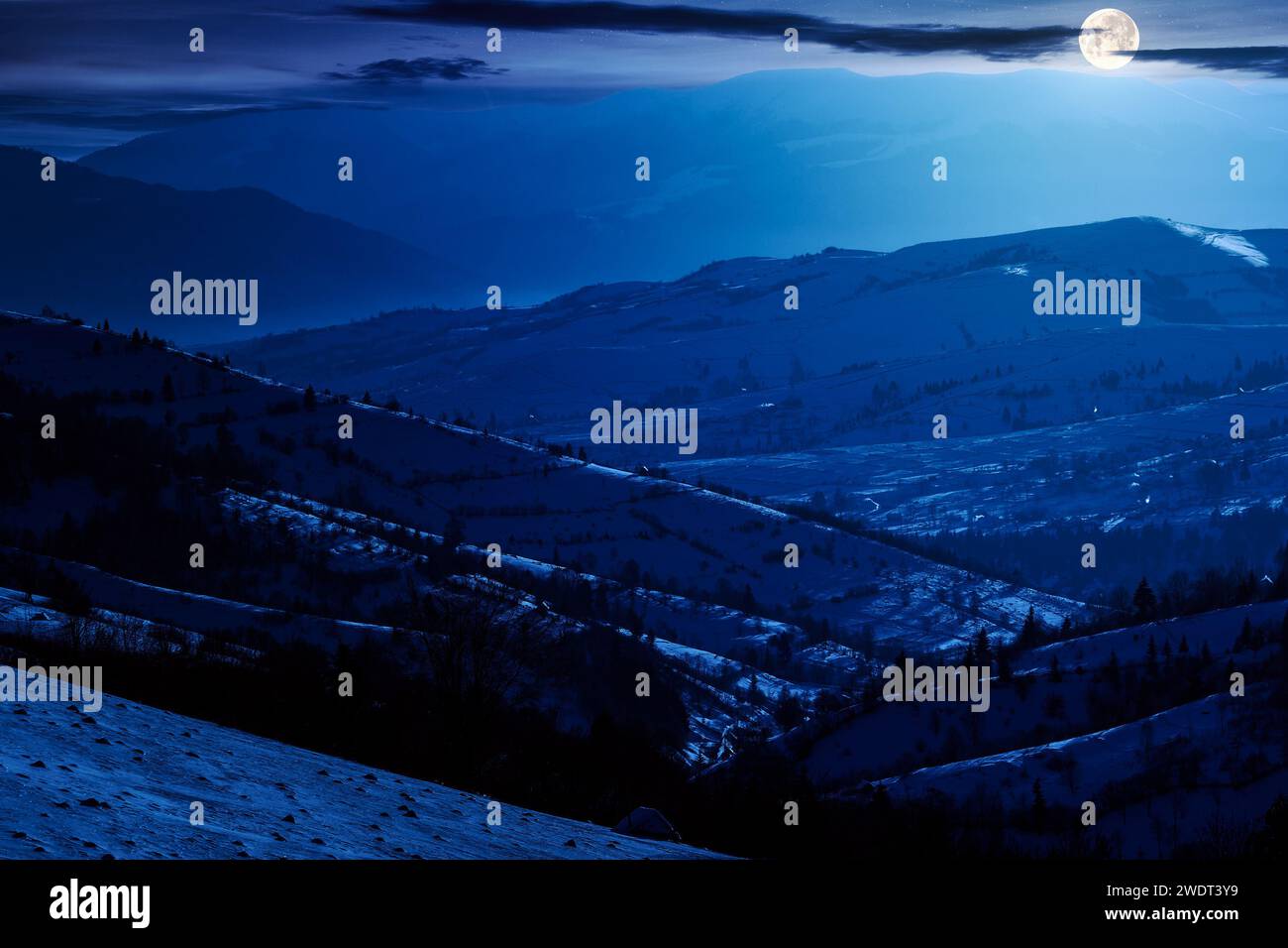 mountainous countryside at night. rural landscape with snow cowered ...