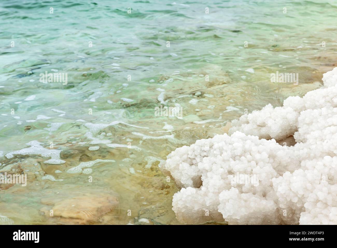 Deposits of mineral salts on the beach. Typical landscape of the Dead Sea in Jordan ...