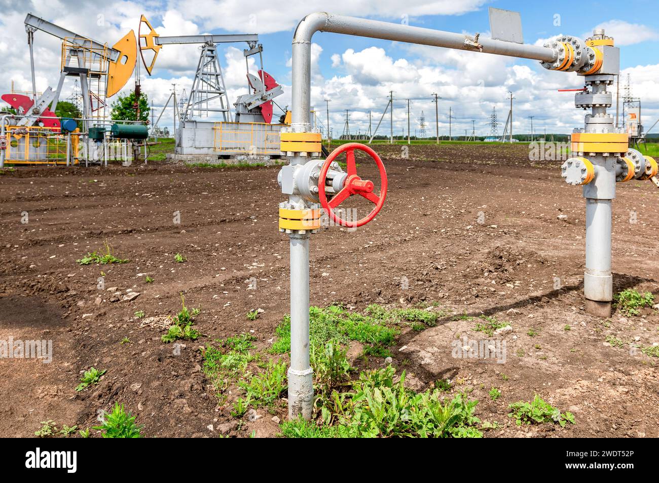 Pipe with control valve against the background pump jack fracking crude ...
