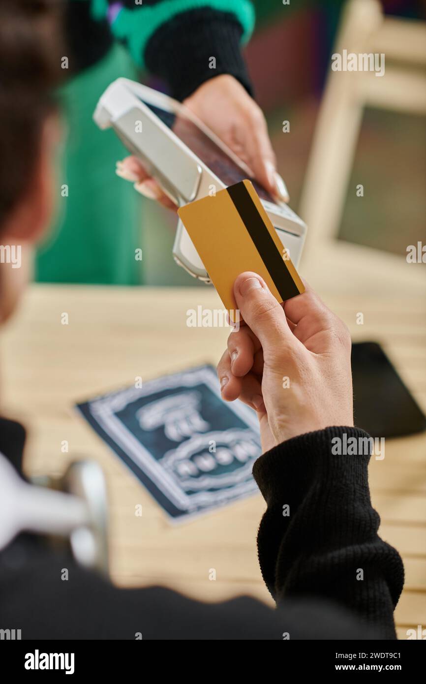customer holding credit card near contactless card reader, cropped hand ...