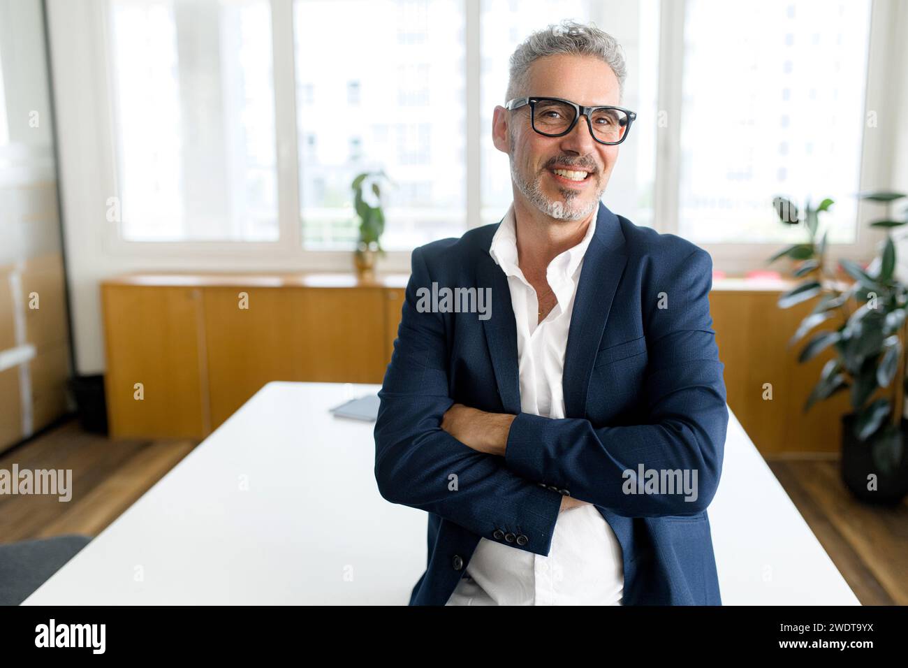 Headshot of high-skilled mature male employee standing with arms ...