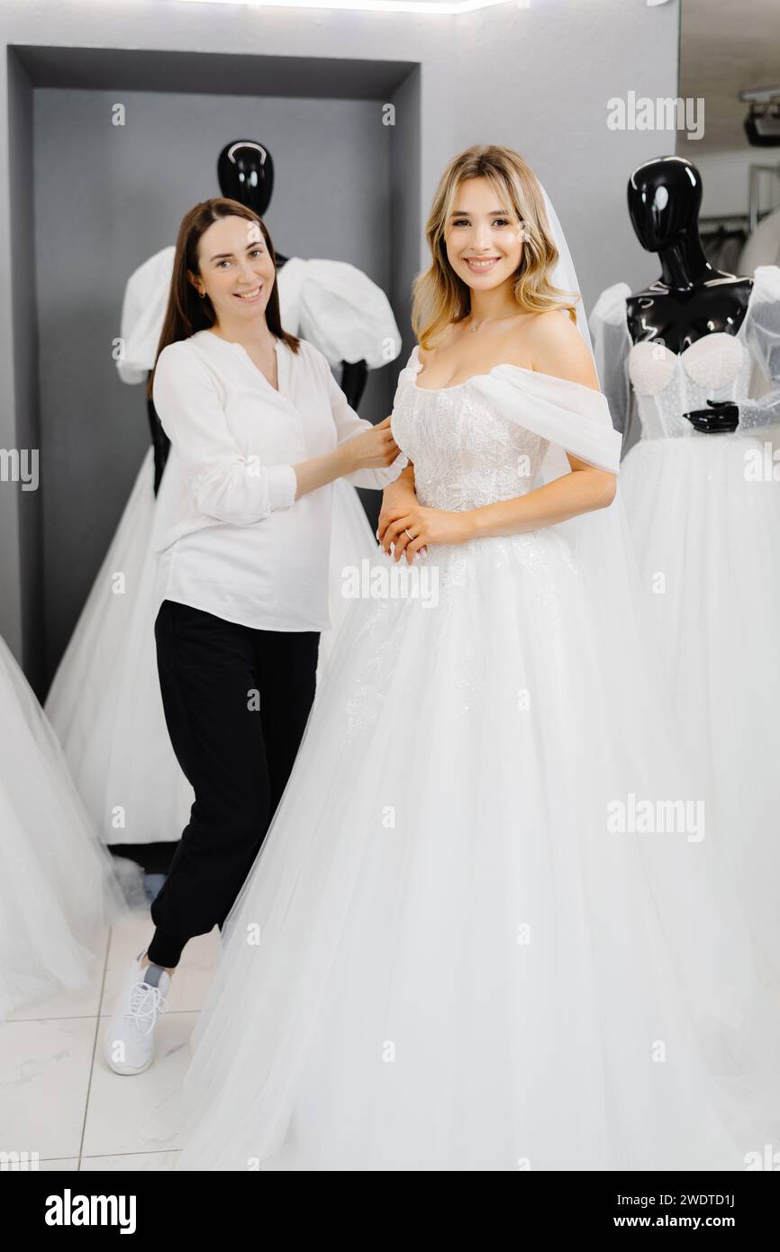 The bride-to-be chooses a dress for the wedding. A dressmaker's ...