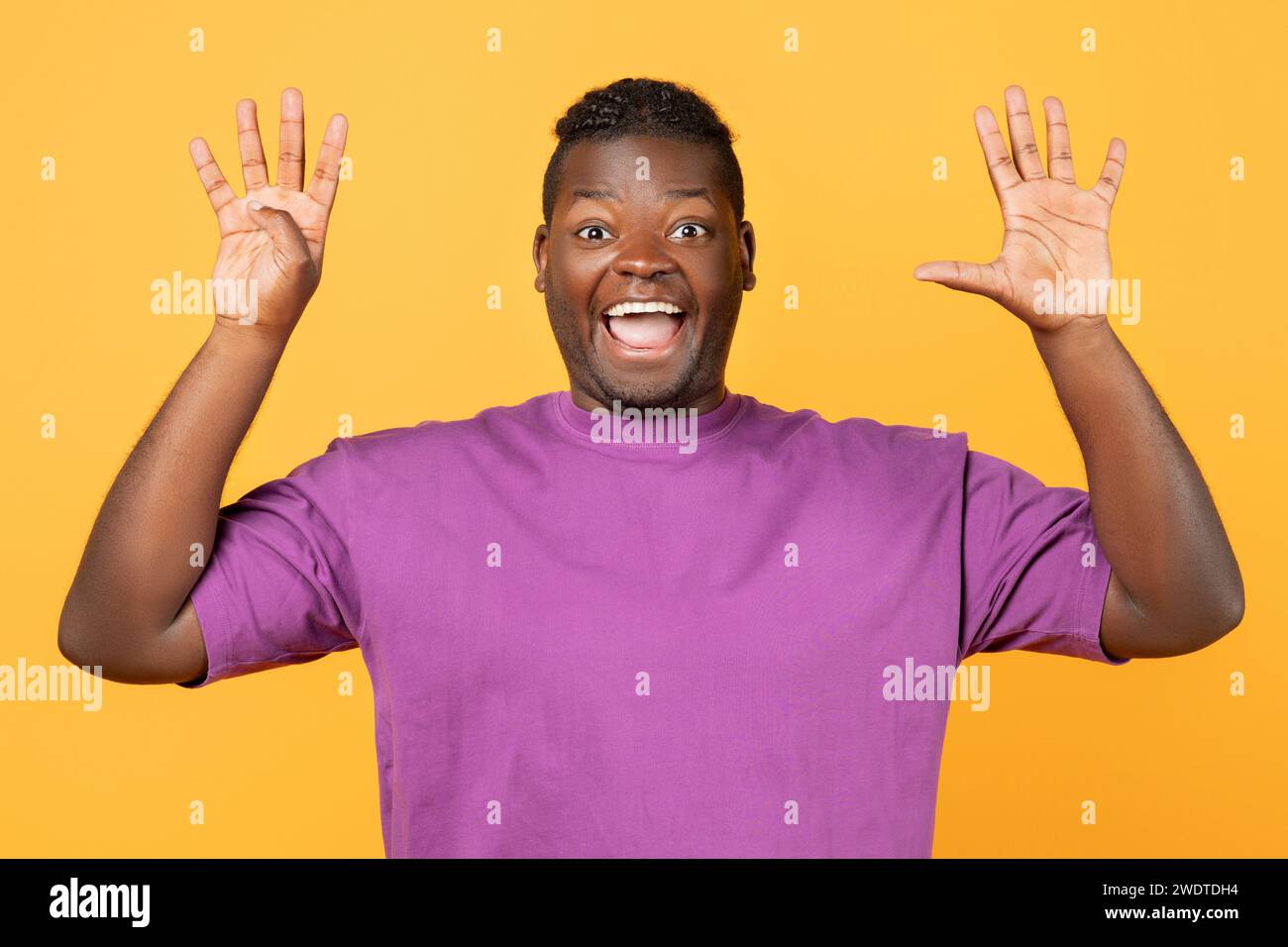 Excited African man raising both hands showing number nine, studio ...