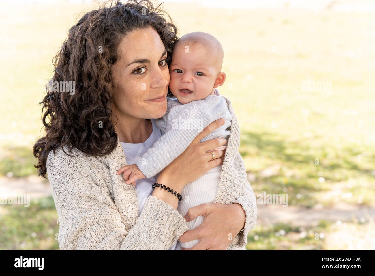 Portrait of a young mother with her small newborn baby in her arms ...