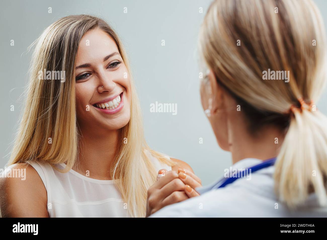 gentle touch of a physician provides reassurance to a smiling ...