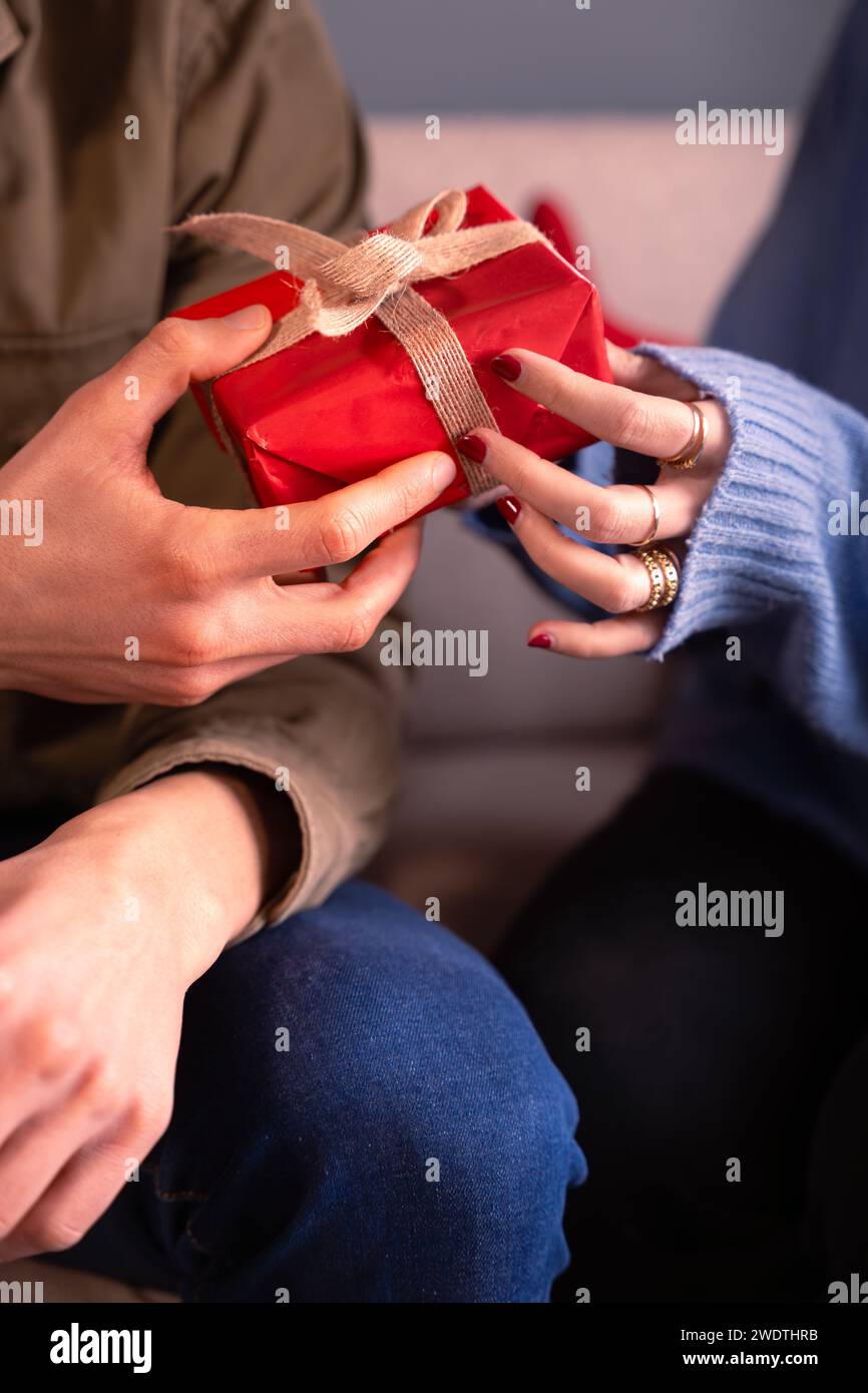 Hands of a man giving a gift to his partner with a bow. Valentine's Day ...