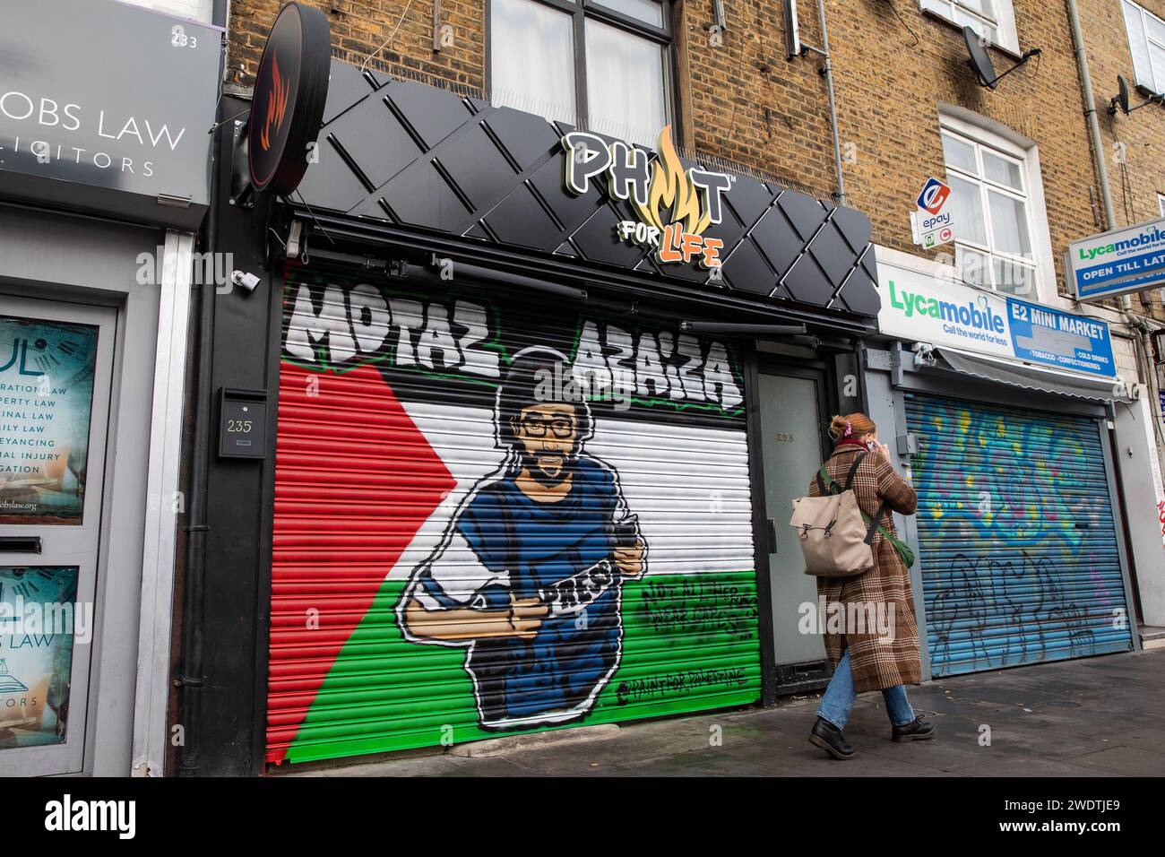London, UK. 21st January, 2024. A member of the public passes artwork ...