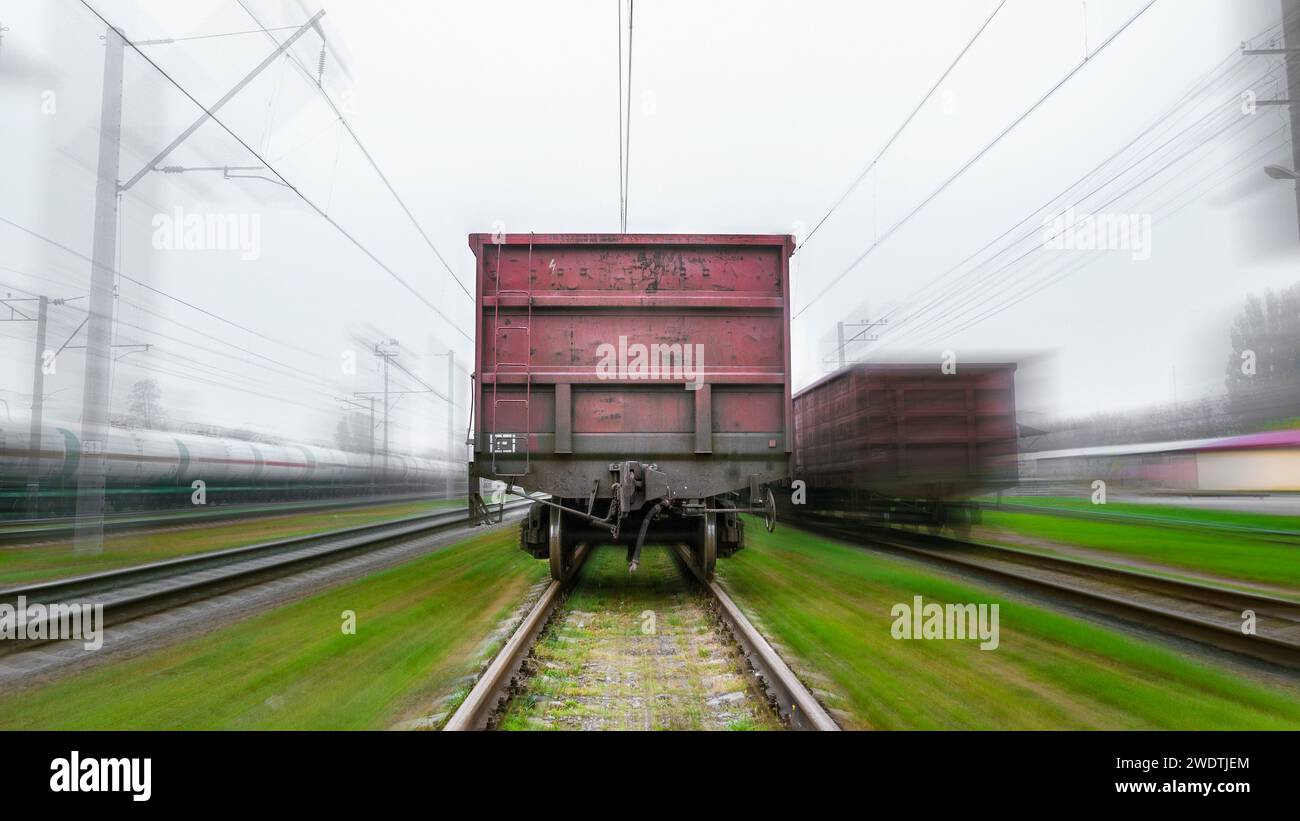 Freight train goes by rail. Back view. Blurred background gives a ...