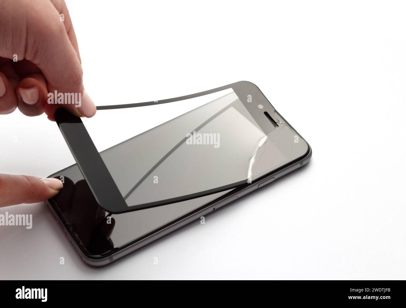 Disconnecting the protective glass from the smartphone on white ...