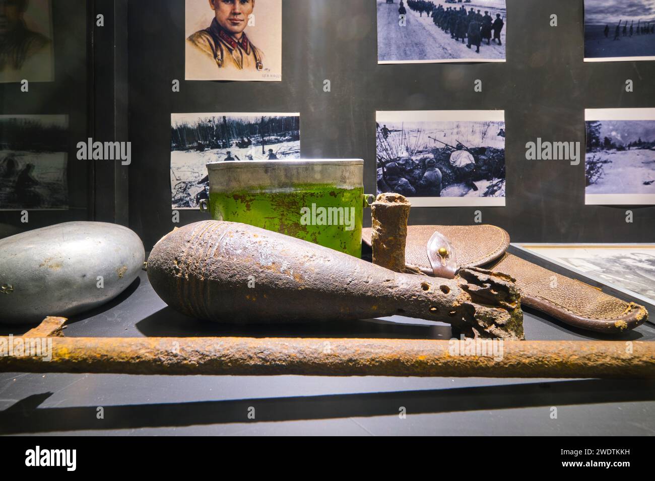 A display featuring a rusted bomb and other military objects. At the ...
