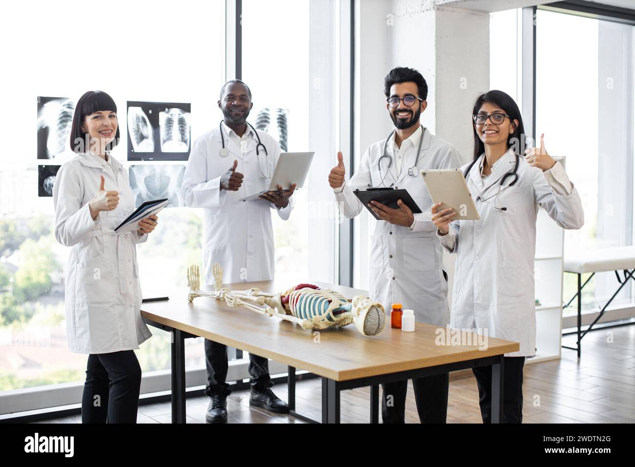 Medical students on anatomy lesson in classroom showing, thumbs up ...