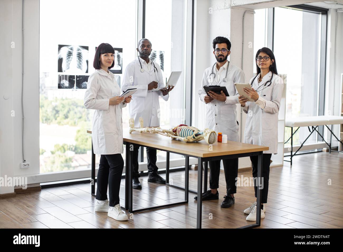 Young medical students on anatomy lesson in classroom looking at camera ...