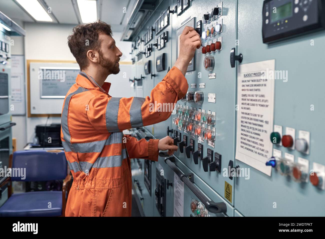 Young engineer working in engine control room on electrical ... Young engineer working in engine control room on electrical ...