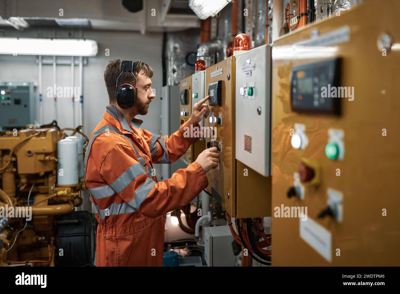 Young engineer officer starting diesel generator manually in engine ...