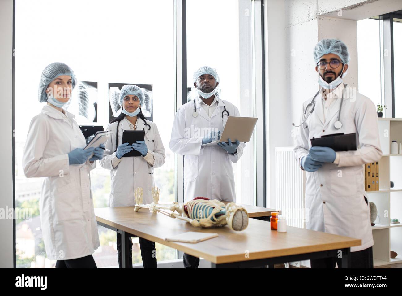 Multiethnic medical students on anatomy lesson in classroom looking at ...