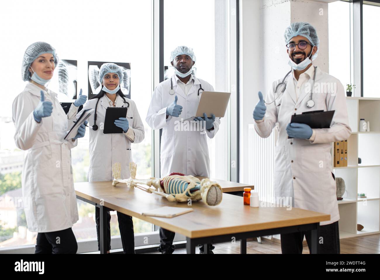 Multiethnic medical students on anatomy lesson in classroom looking at ...