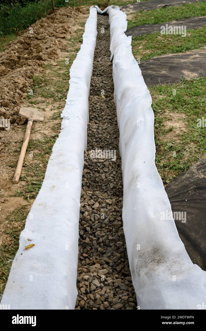 The drainage trench is covered with geotextile and filled with crushed ...
