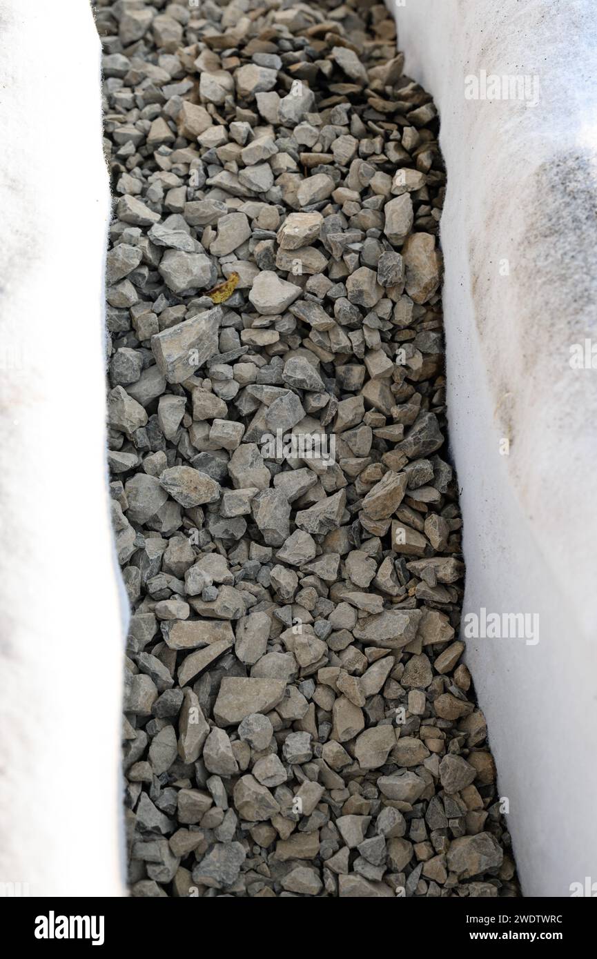 The drainage trench is covered with geotextile and filled with crushed ...