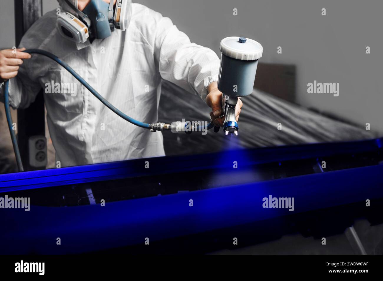Male car service worker sprays dye on the elements part of car. Car ...