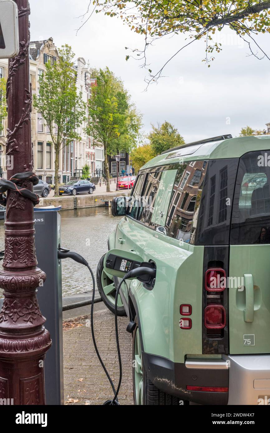 Electric plug-in hybrid Land Rover Defender charging on the canal side ...