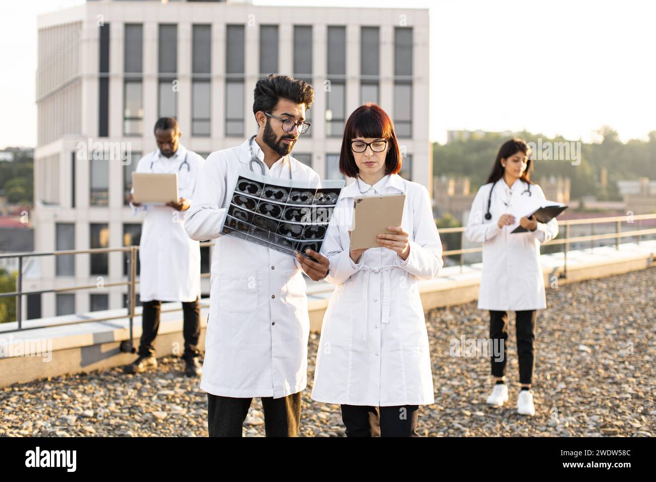 Bearded doctor in white lab coat presenting MRI x-ray to young ...