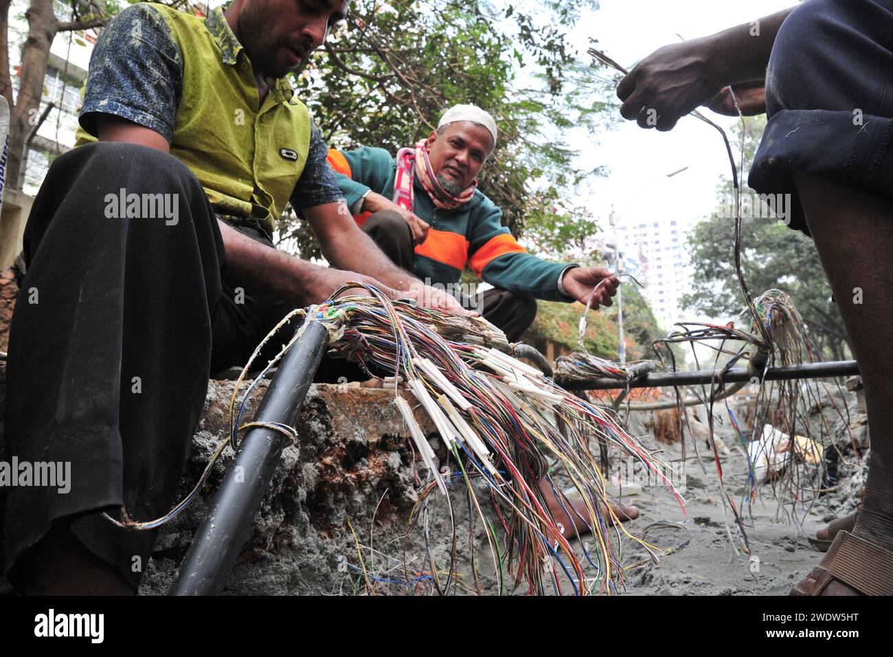 Technician repairing an underground telephone line multi colored wires ...