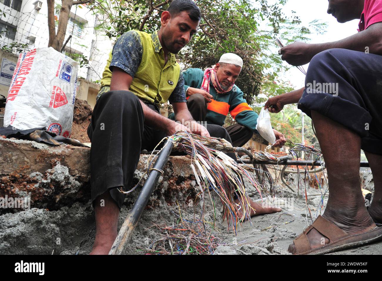 Technician repairing an underground telephone line multi colored wires ...