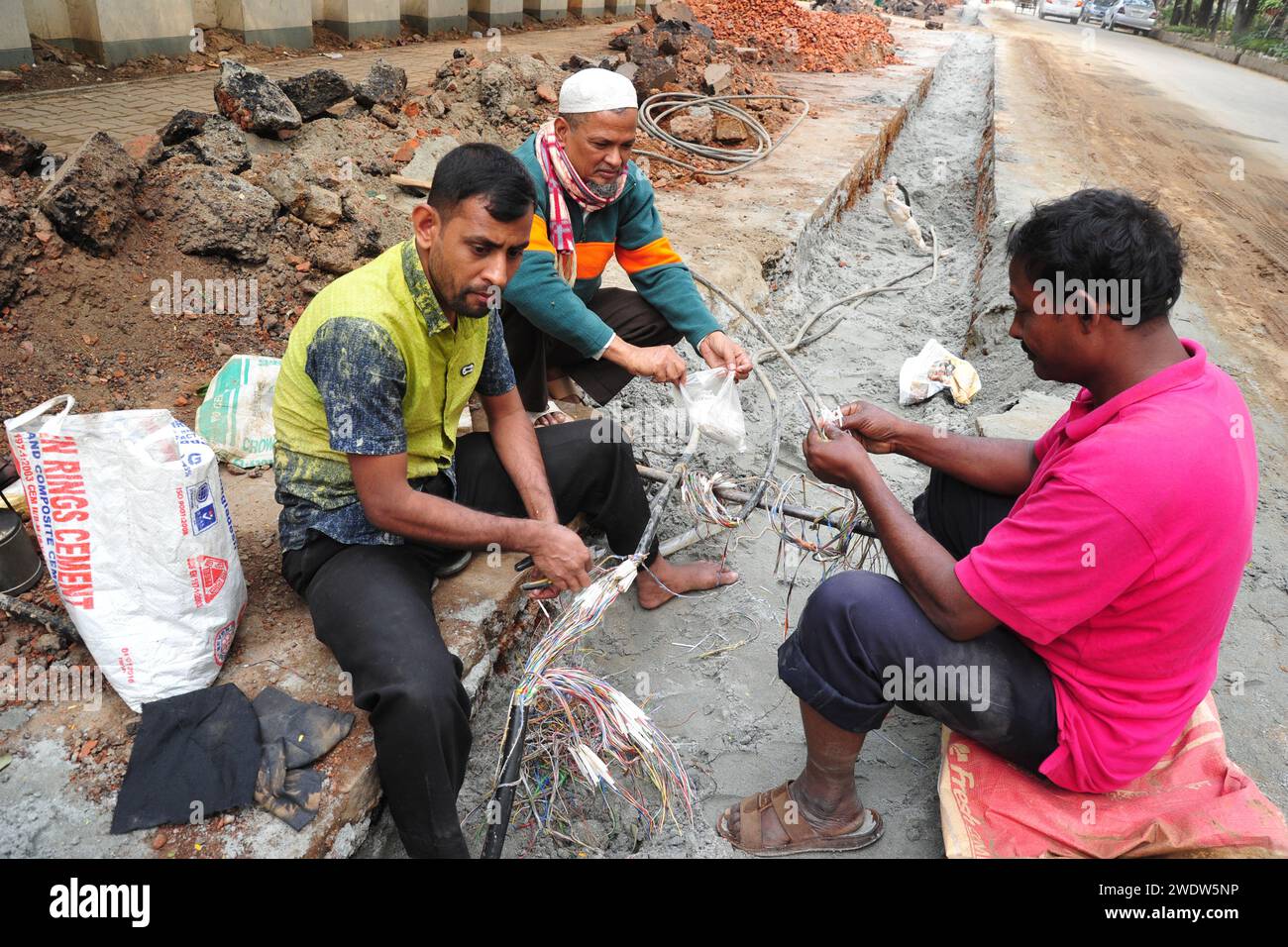 Technician repairing an underground telephone line multi colored wires ...