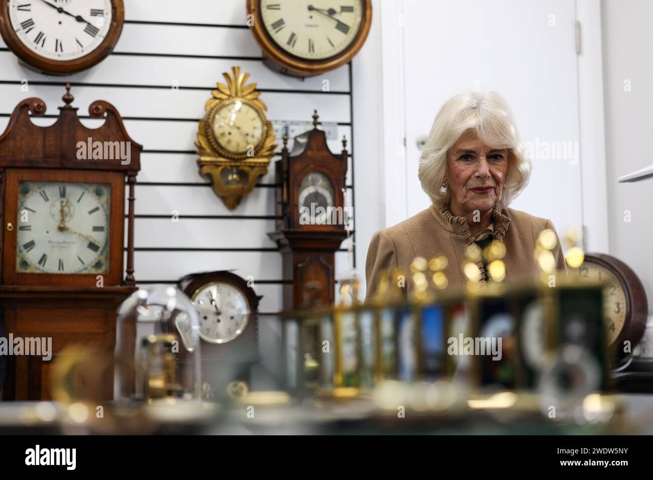 Queen Camilla views a selection of carriage clocks during a visit to Deacon & Son, one of the ...