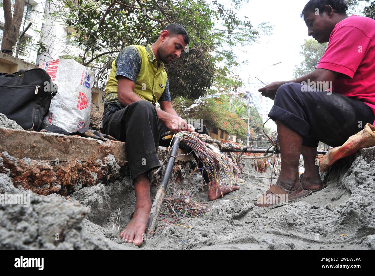 Technician repairing an underground telephone line multi colored wires ...