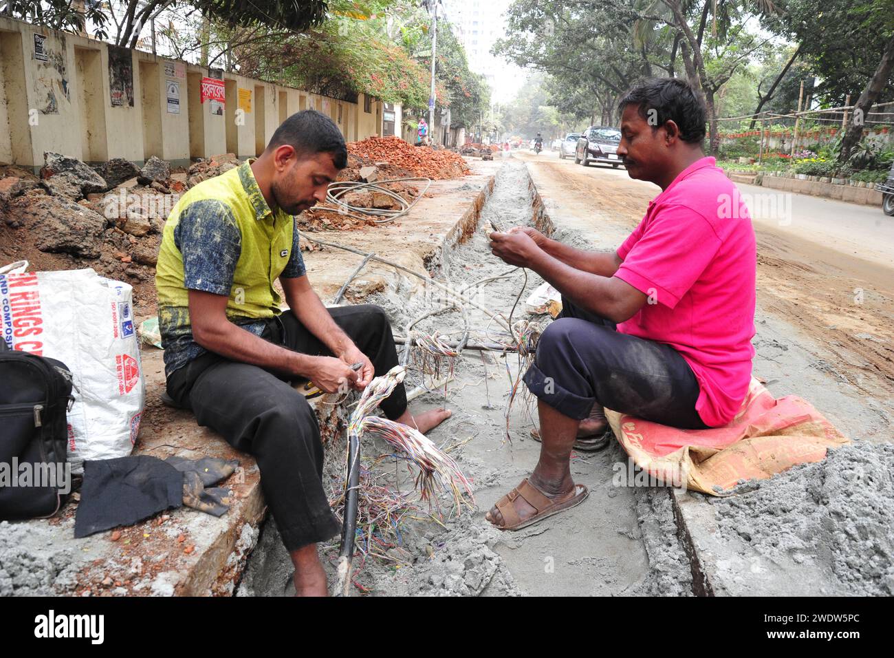 Technician repairing an underground telephone line multi colored wires ...