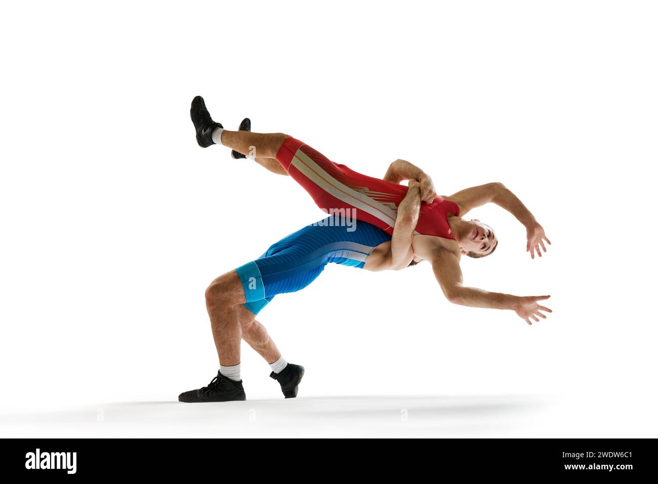 One wrestler in red uniform thrown by opponent in blue, both captured ...