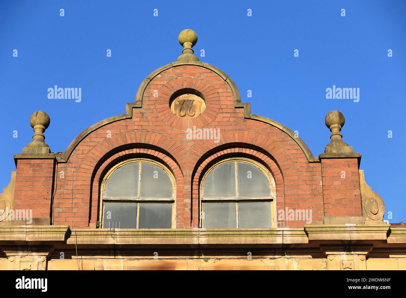 Red brick building, dutch gable with two attic windows and three ball ...
