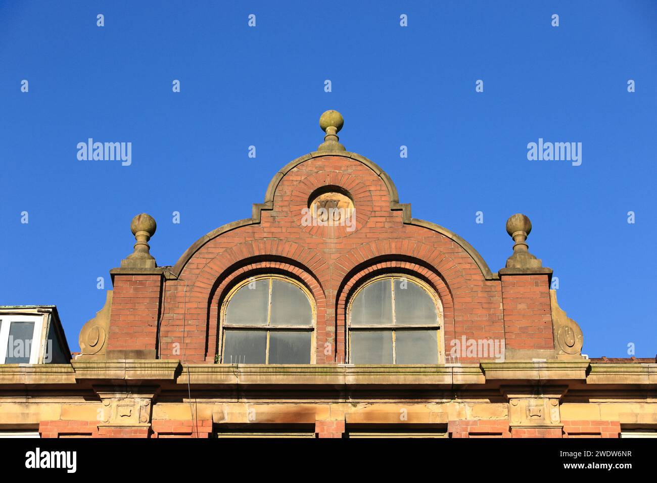 Red brick building, dutch gable with two attic windows and three ball ...