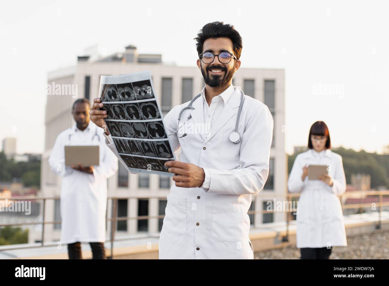 Male doctor holding x-ray scan of patient during break outdoors ...