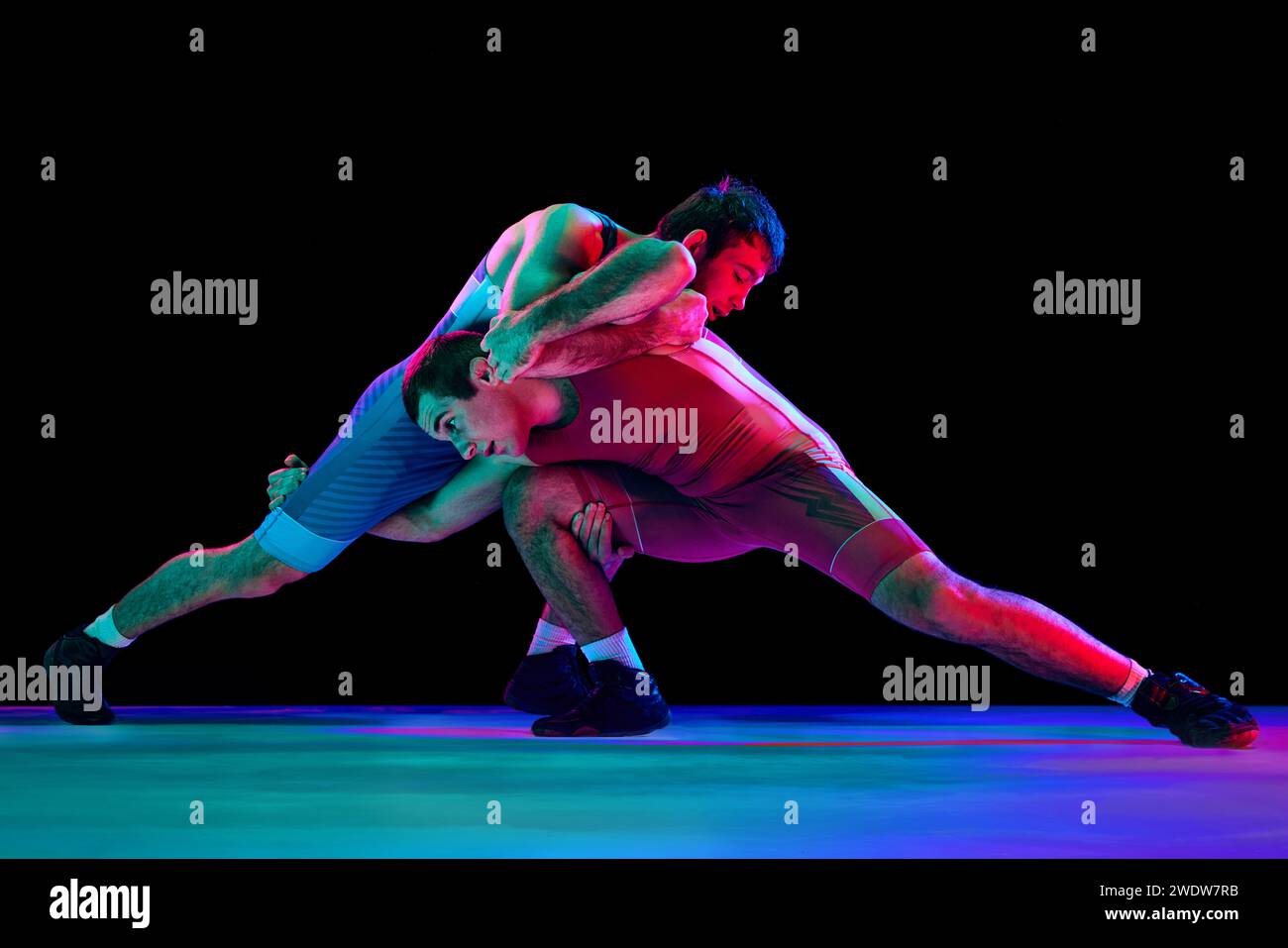 Two young athlete man, skilled wrestlers in red and blue uniform ...