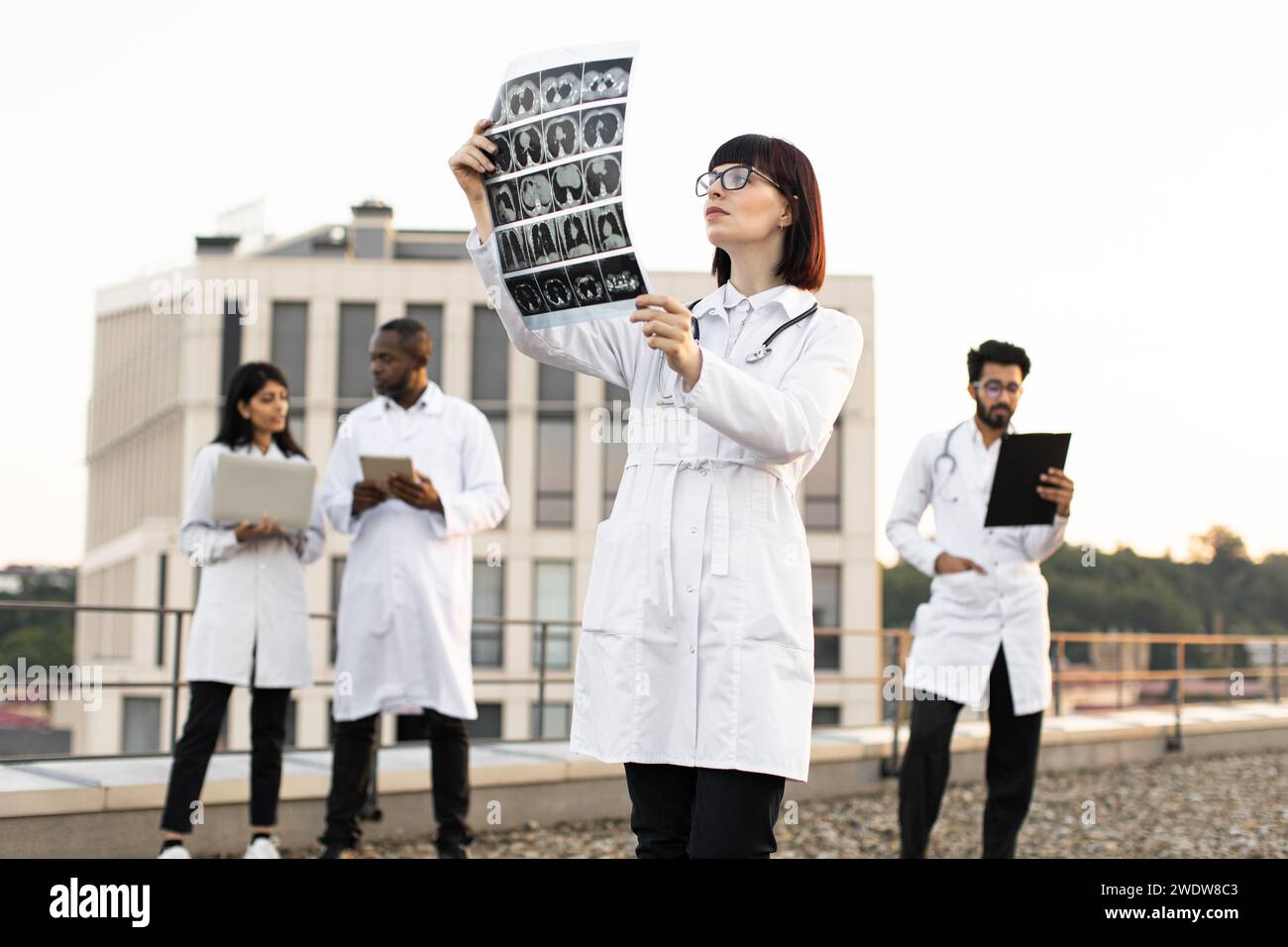Caucasian doctor holding x-ray scan of patient during break outdoors ...