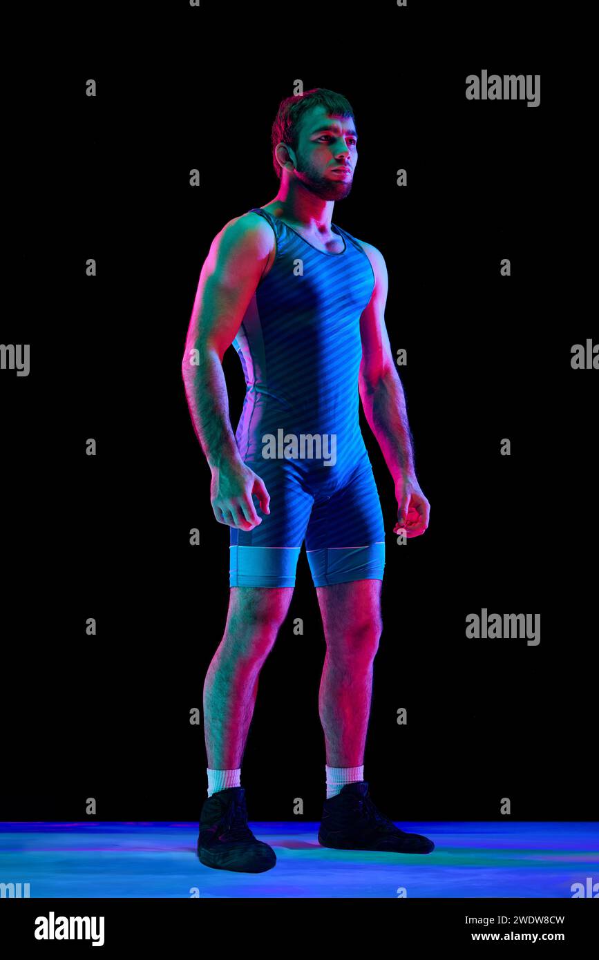 Full length portrait of sporty man in blue fighting uniform posing ...