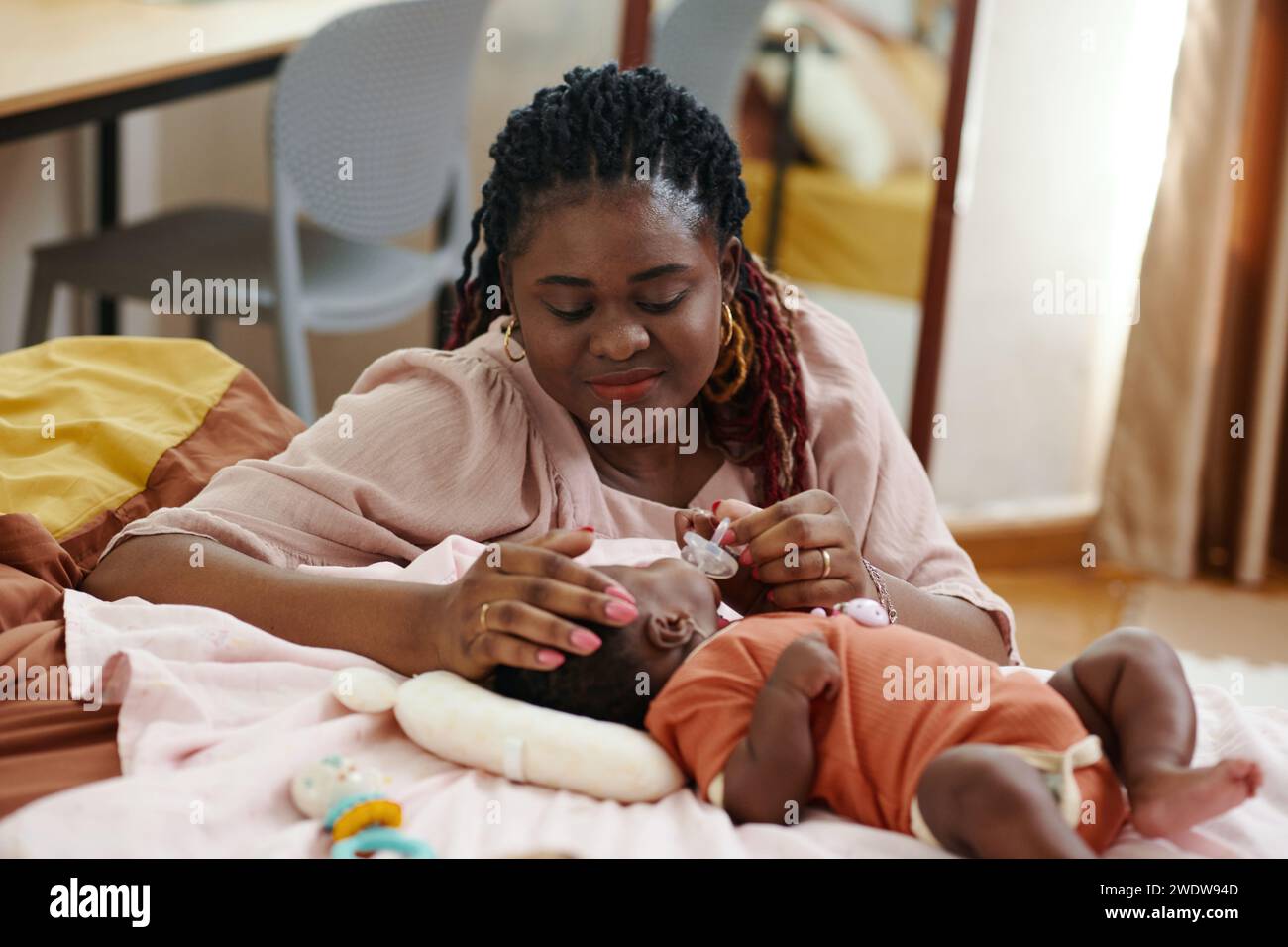 Caring mother giving pacifier to newborn baby to calm down child Stock ...
