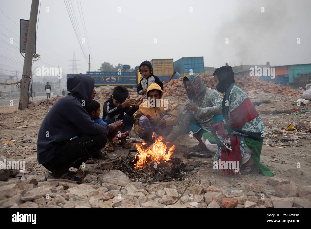 Dhaka, Bangladesh. 22nd Jan, 2024. People warm themselves around a bon ...