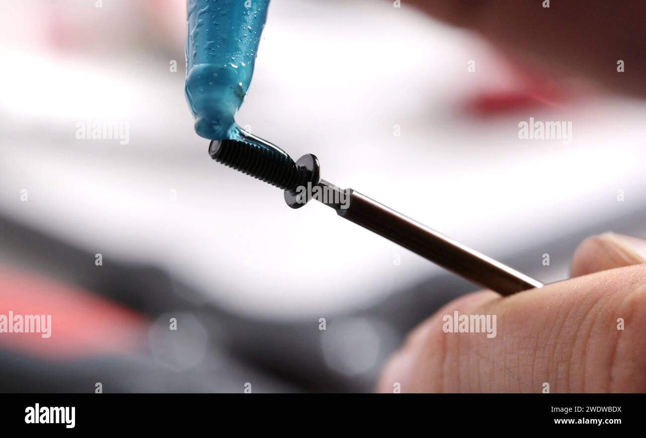 Using blue thread lock liquid for screws Stock Photo - Alamy