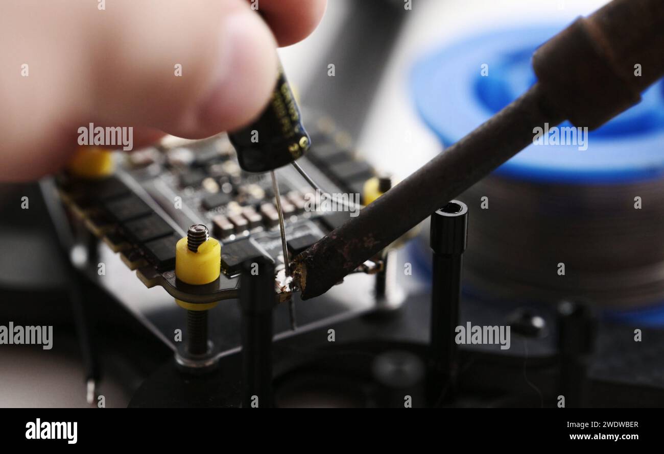Process of soldering condensator into microchip of fpv copter Stock ...