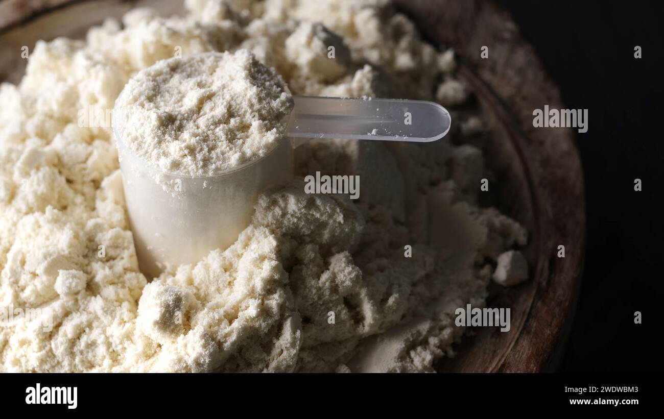 Measuring spoon filled with dry protein whey Stock Photo - Alamy